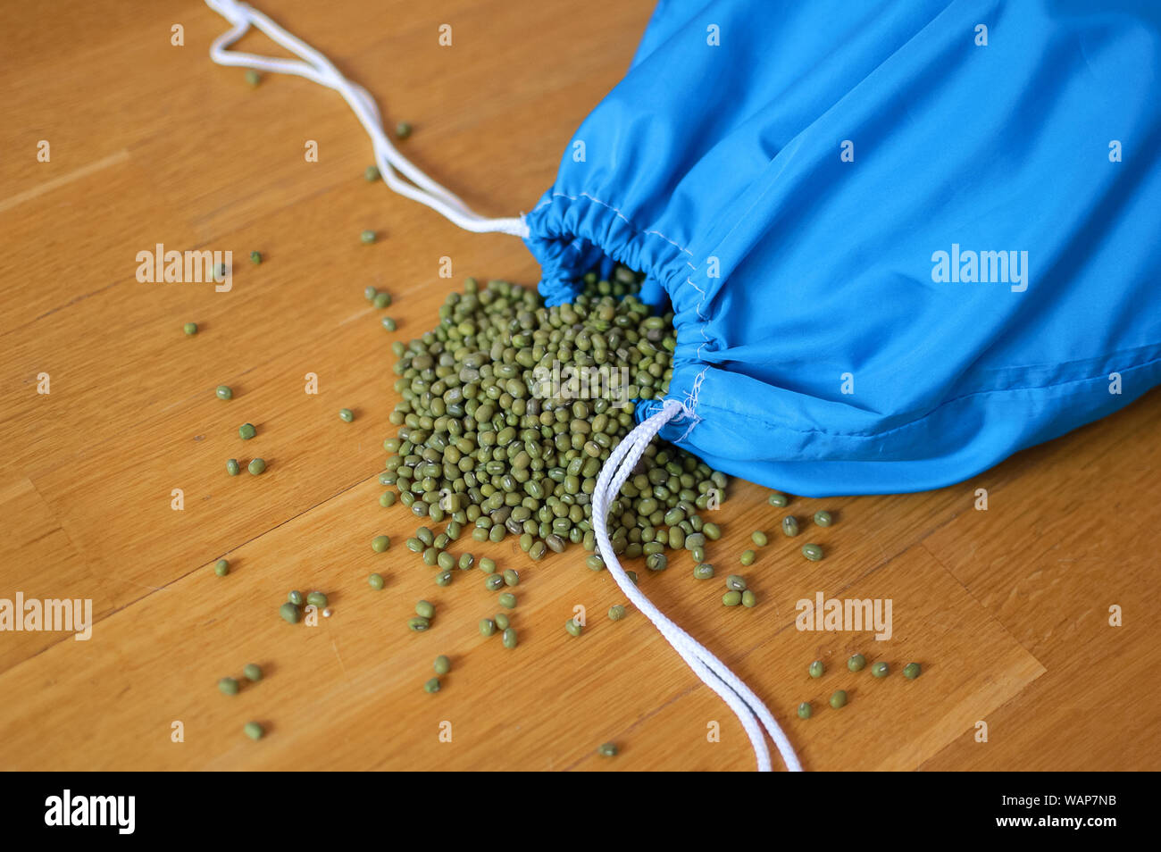 Green mung bean in blue reusable package on wooden background. Eco ...