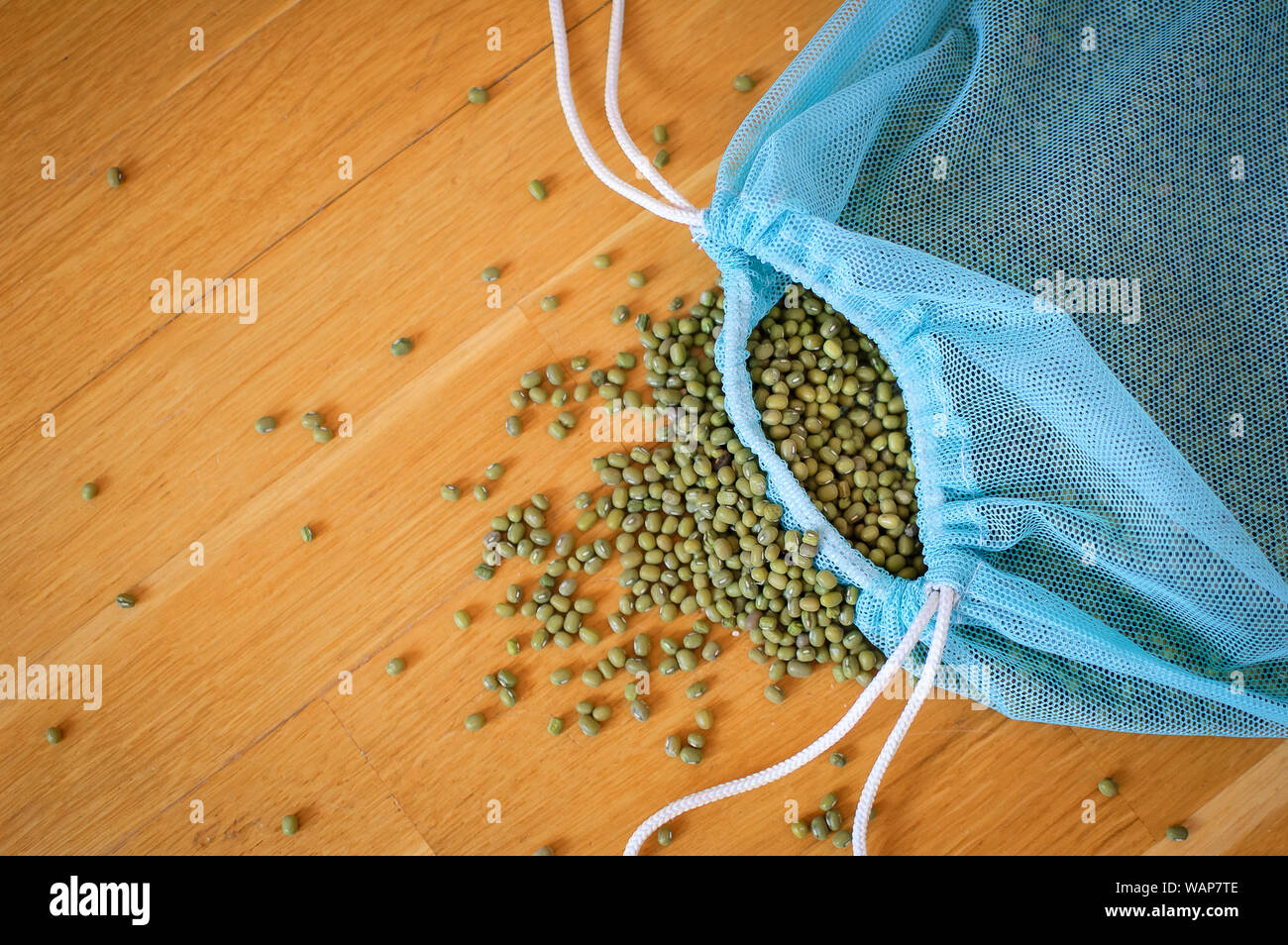Top view of green mung bean in blue reusable package on wooden ...