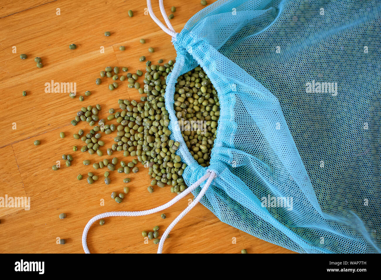 Top view of green mung bean in blue reusable package on wooden ...