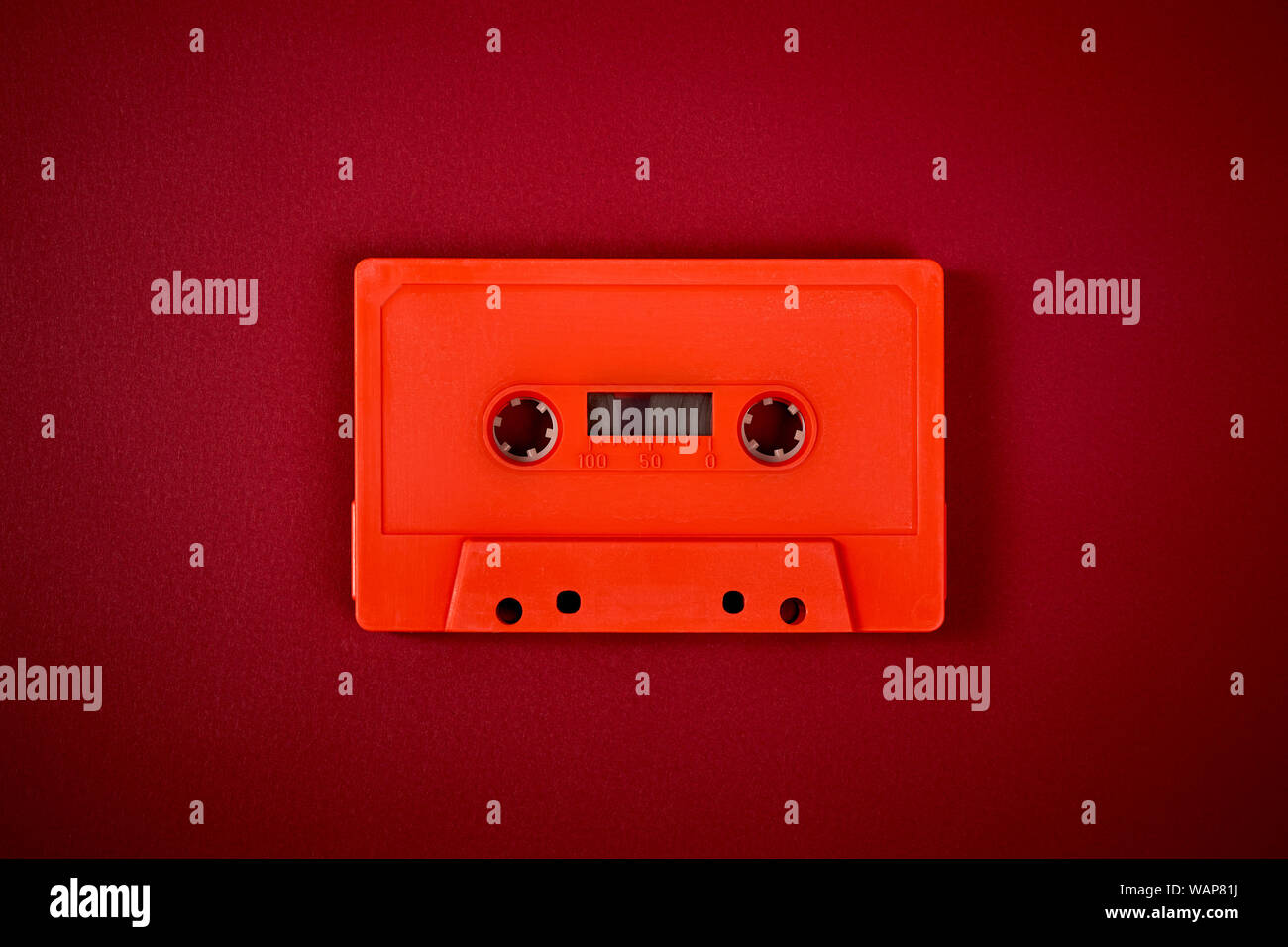 orange audio cassette on the dark red background Stock Photo - Alamy