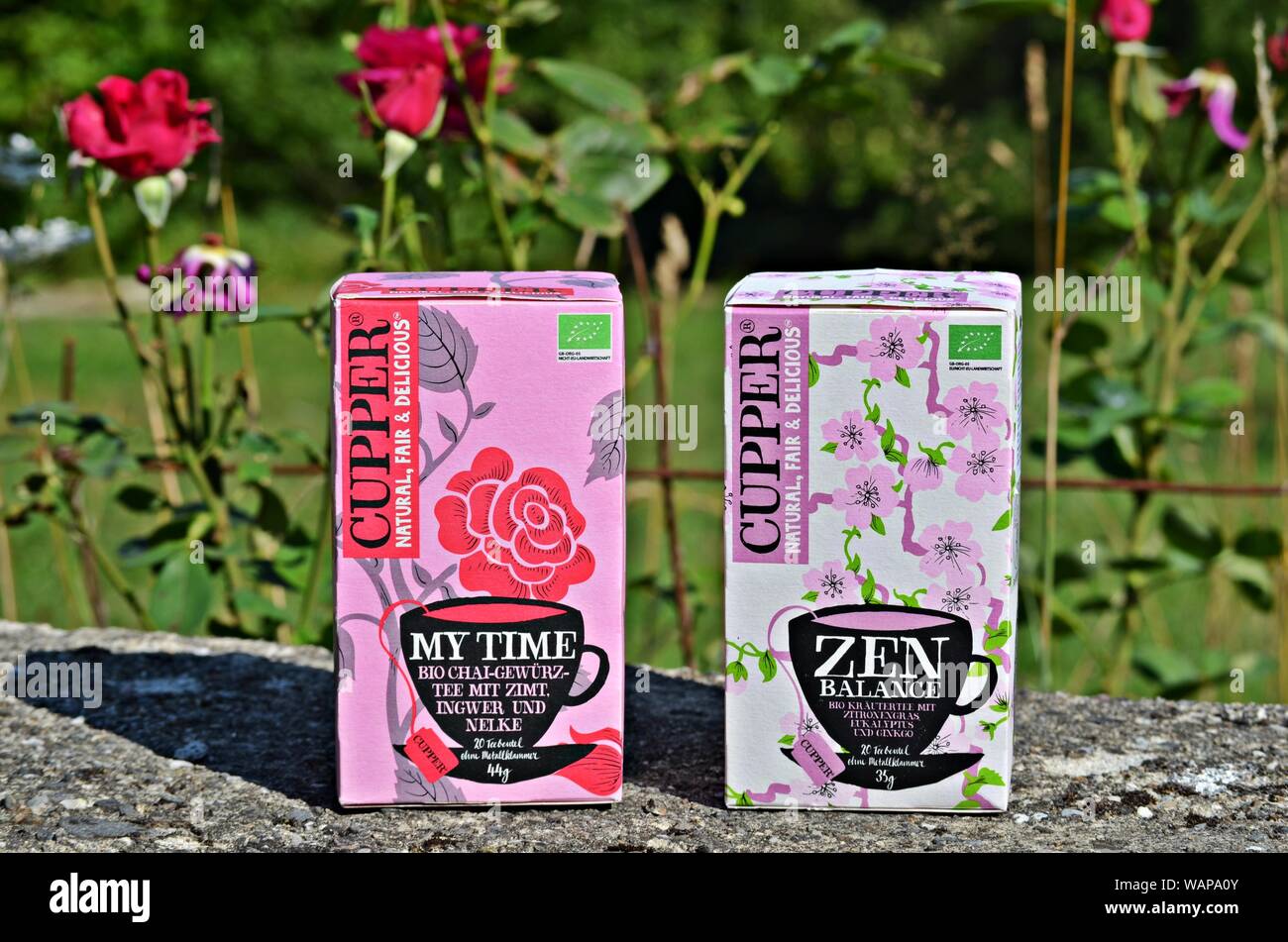 Packagings of Cupper Teas/Infusions photographed on a concrete fence ...