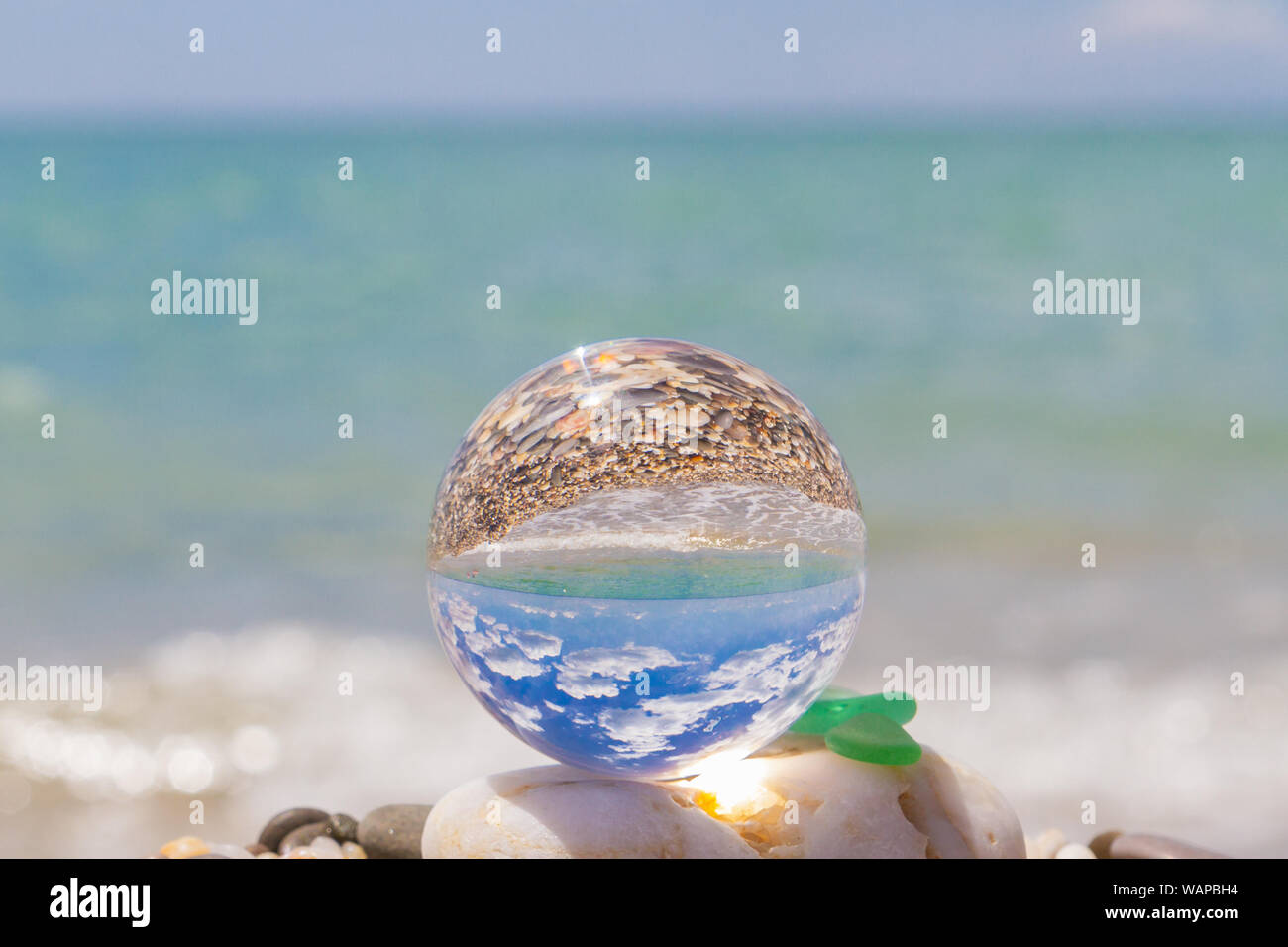 Glass round ball on the beach reflects the sea in summer Stock Photo ...