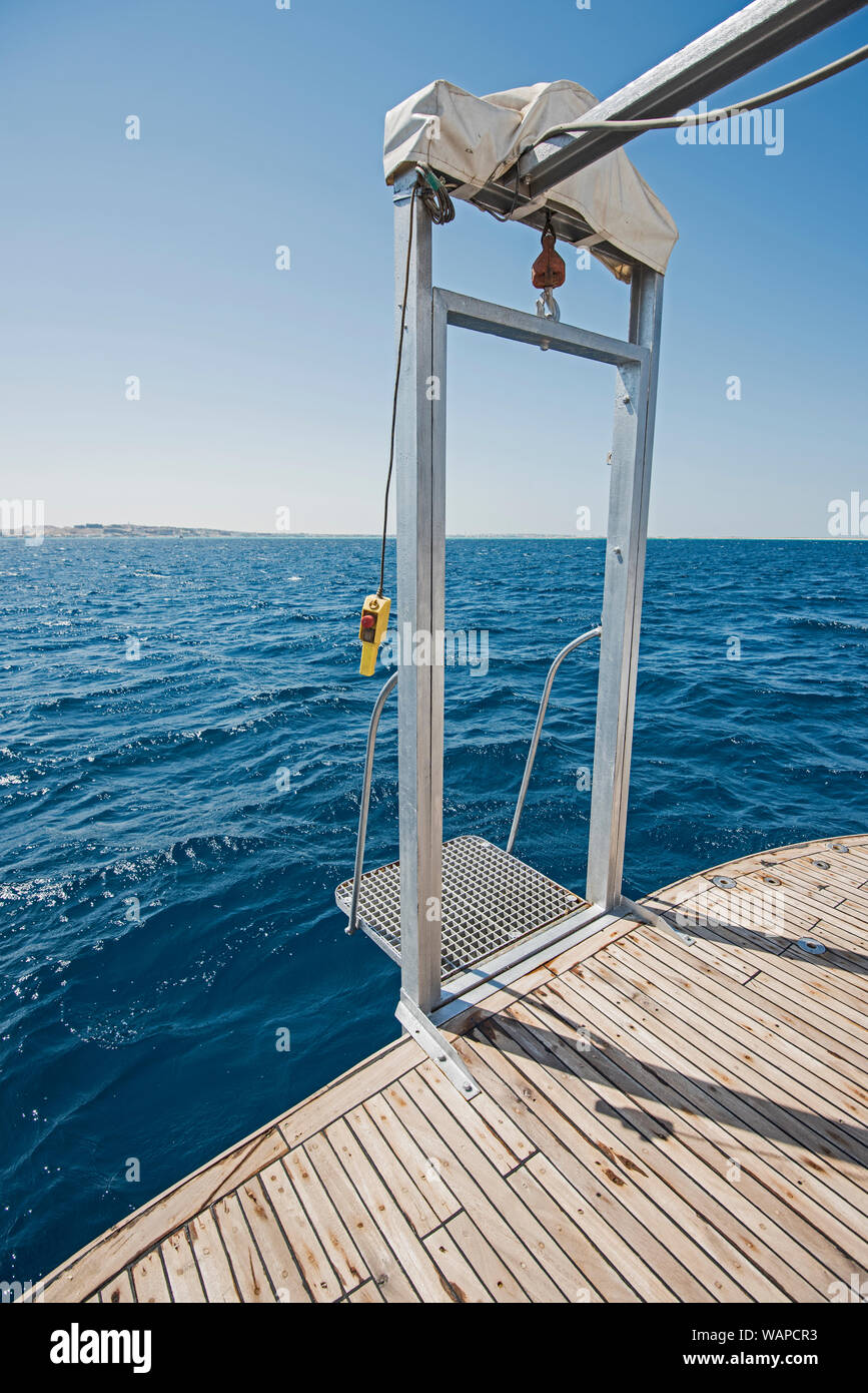 Metal steel diver lift on back teak deck of a large luxury motor yacht ...