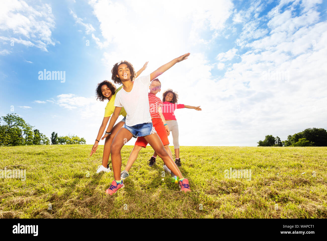 Group of boy and girls smile bending with hands Stock Photo - Alamy