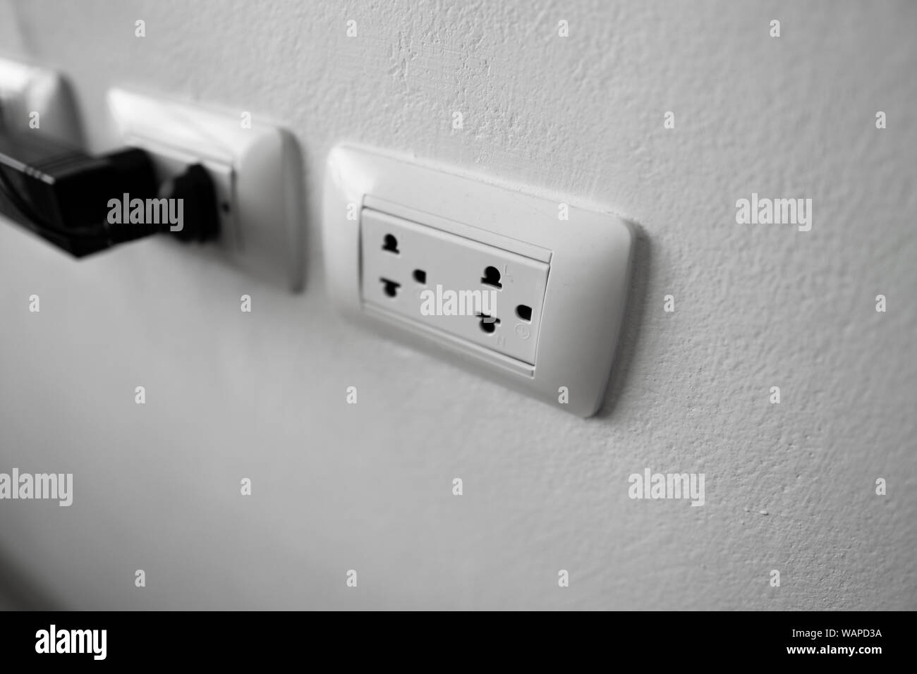 White universal electricity sockets plug on a white wall Stock Photo ...