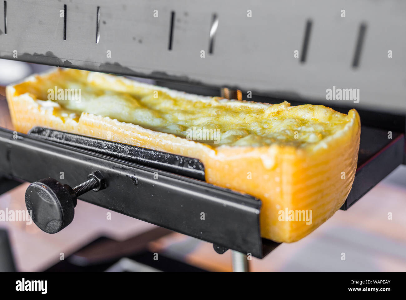 Raclette grilled melted cheese at a street food market Stock Photo - Alamy