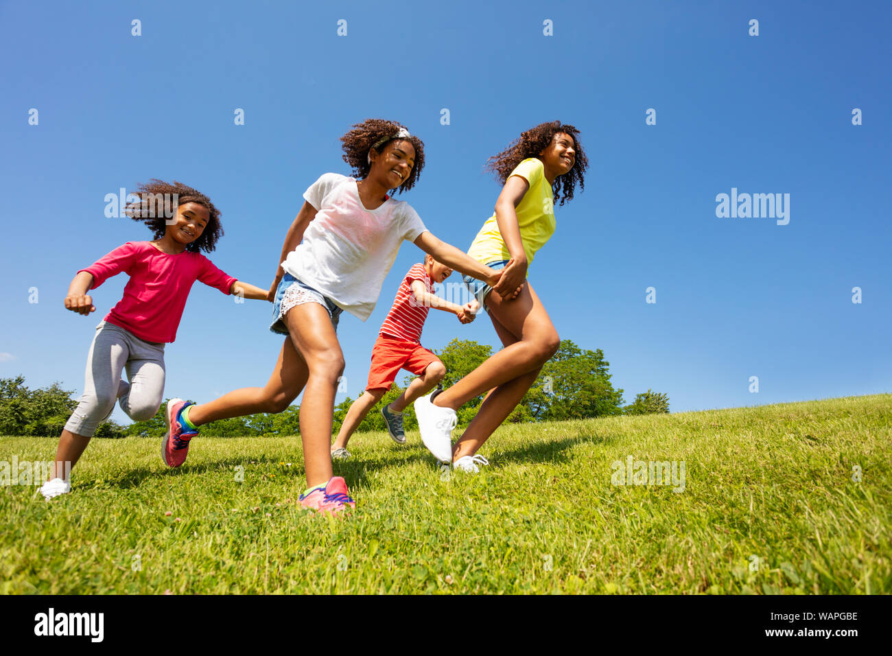 Girl pull kids running fast in the park field Stock Photo - Alamy