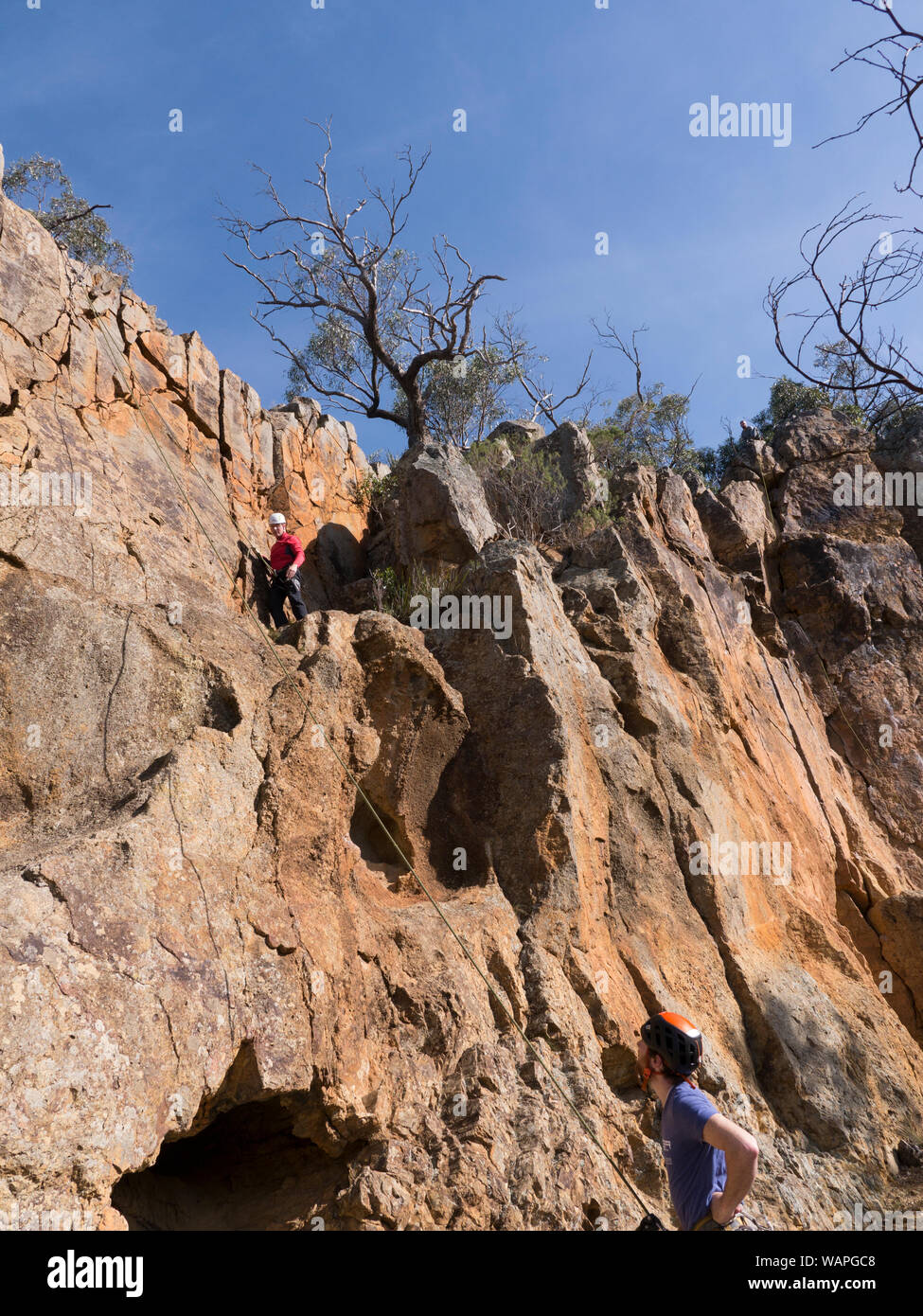 Technical climbing instructor, belaying a novice climber and showing ...