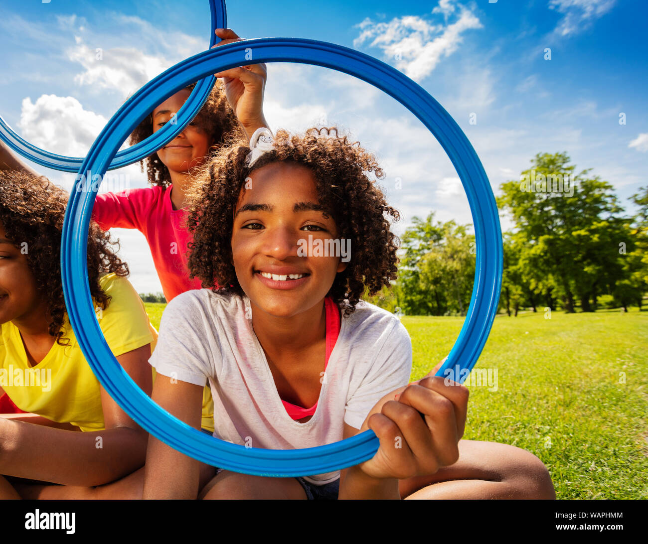 Girl in group of children look inside color hoop Stock Photo - Alamy
