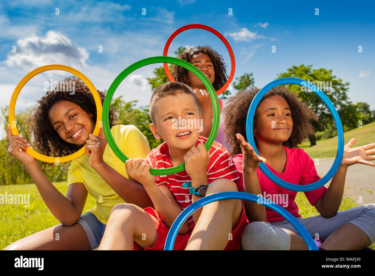kids look through color hoops with funny portraits Stock Photo - Alamy