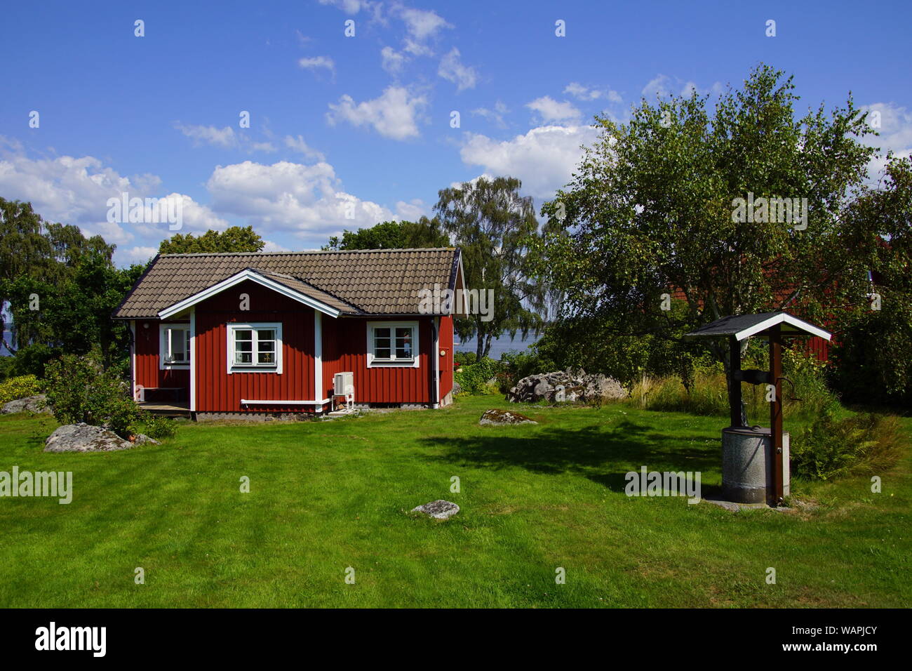 Traditional Swedish cottage in the countryside against a partly clouded ...