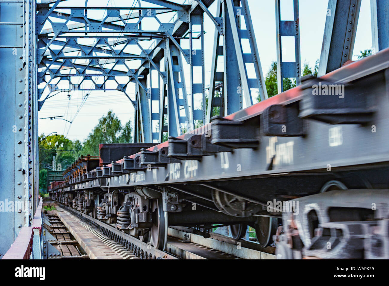 Freight train moves fast through the railway bridge Stock Photo - Alamy