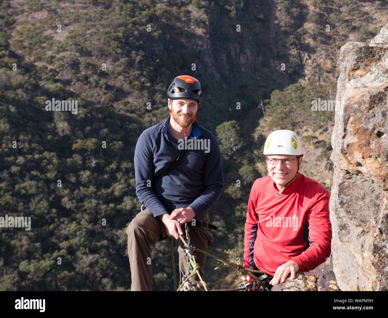 Technical climbing instructor and new student, standing on cliff edge ...