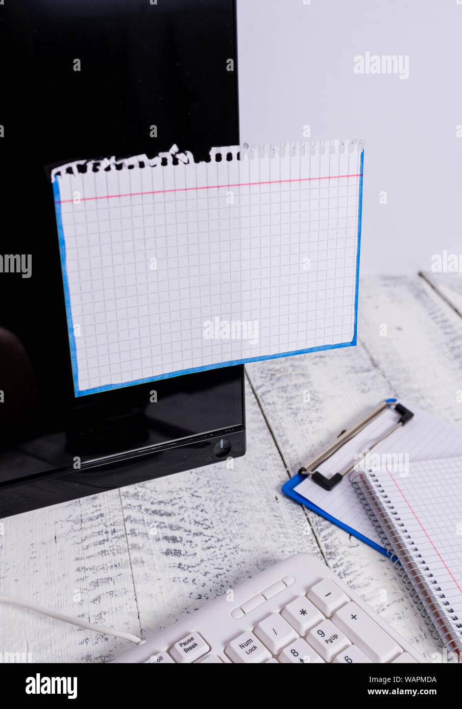 Note paper taped to black computer screen near keyboard and stationary ...