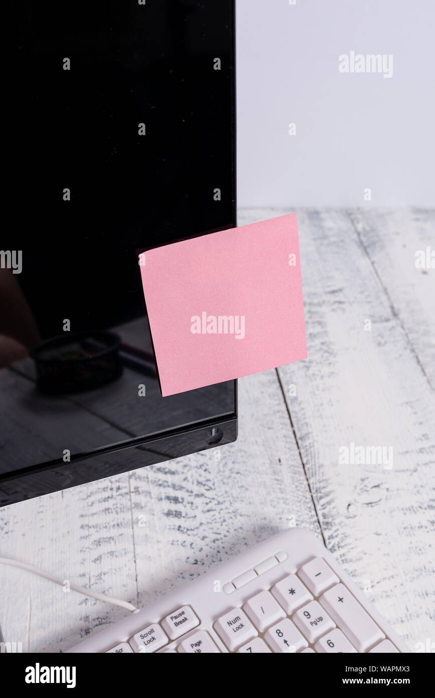 Notation paper taped to black computer monitor screen near white ...