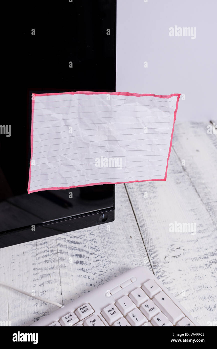 Notation paper taped to black computer monitor screen near white ...