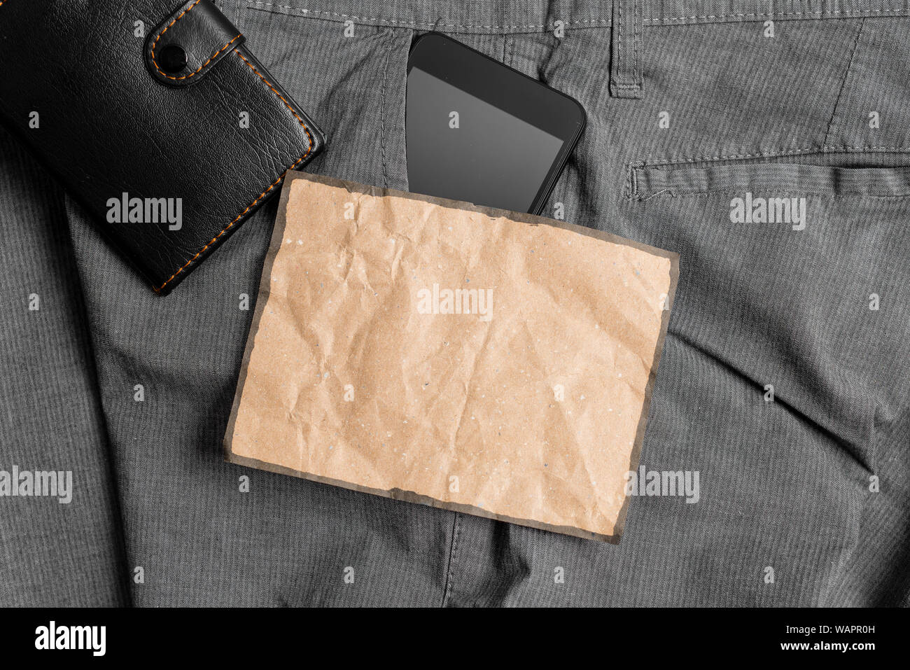 Smartphone device inside trousers front pocket with wallet and note ...