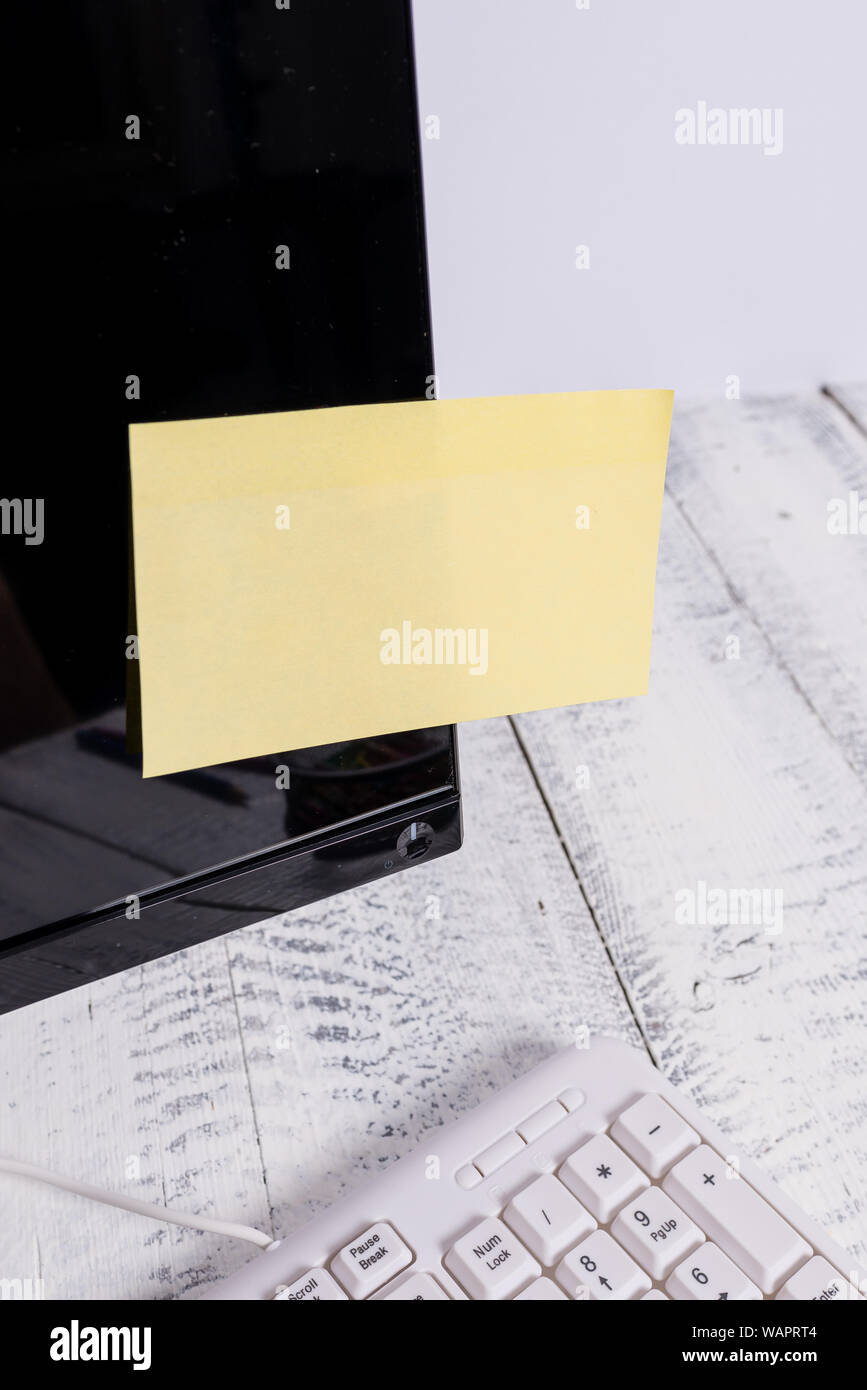 Notation paper taped to black computer monitor screen near white ...