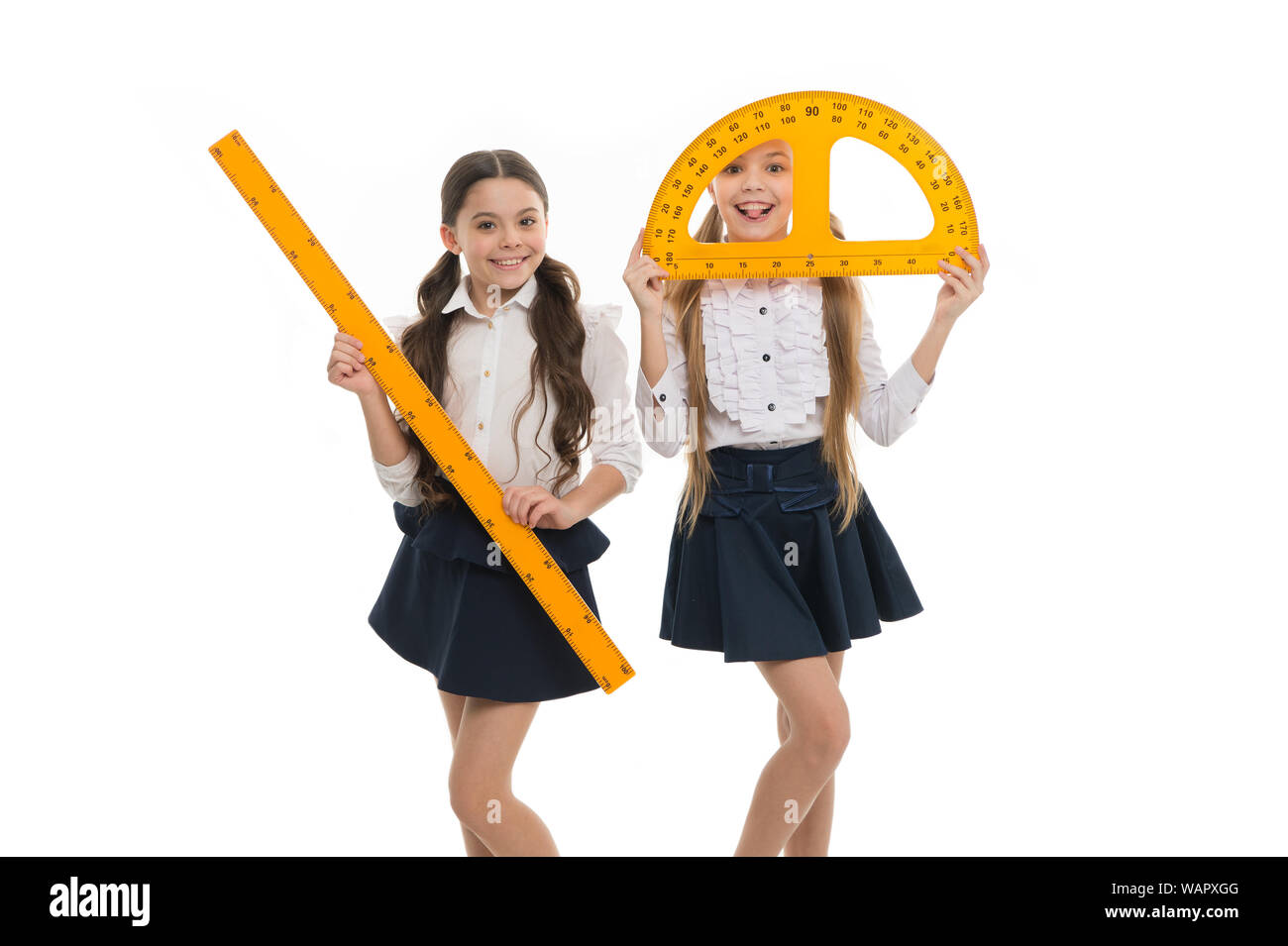 Geometry lesson is much fun. Little girls holding protractor and ruler ...