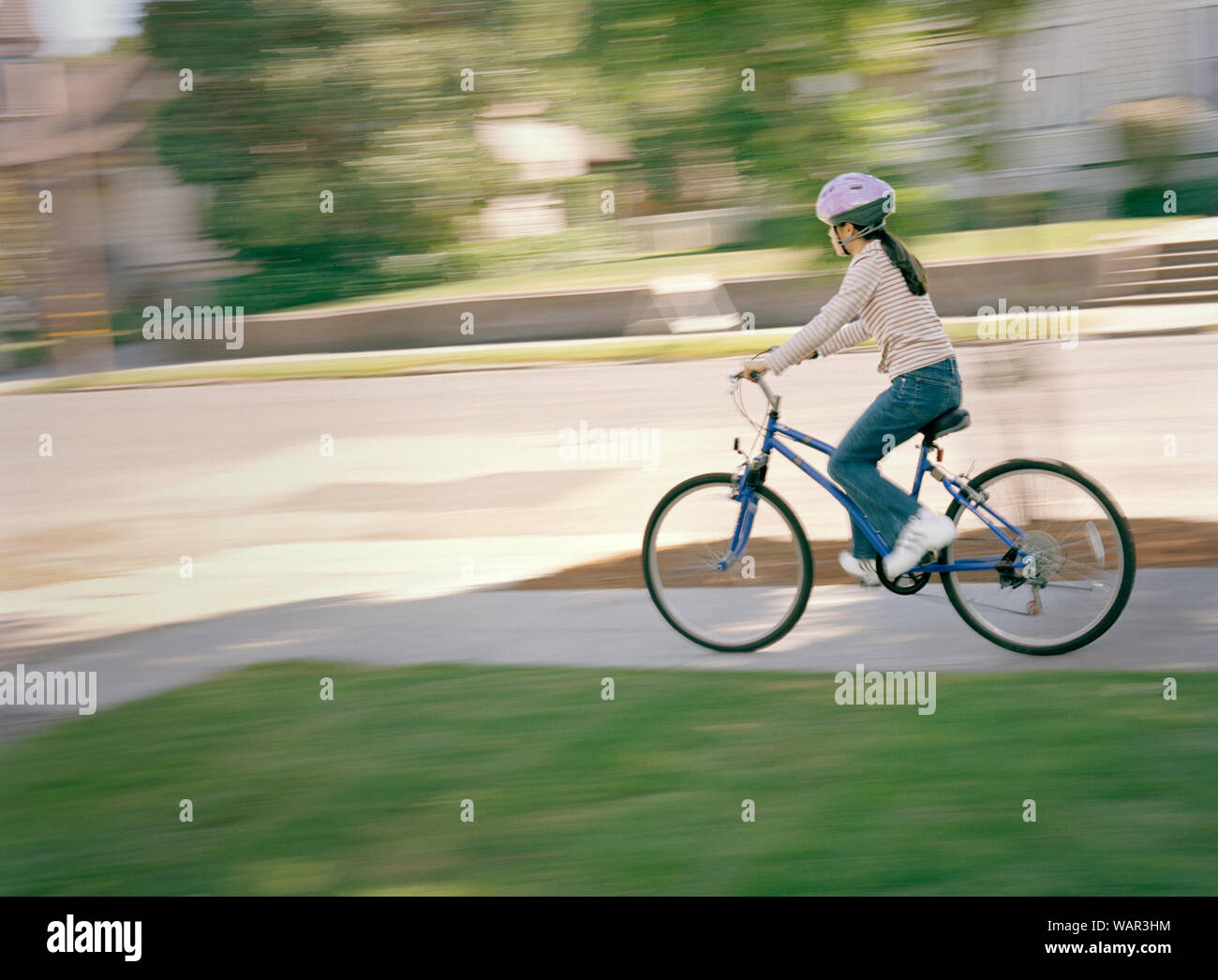Teenage girl riding her bicycle at speed Stock Photo - Alamy