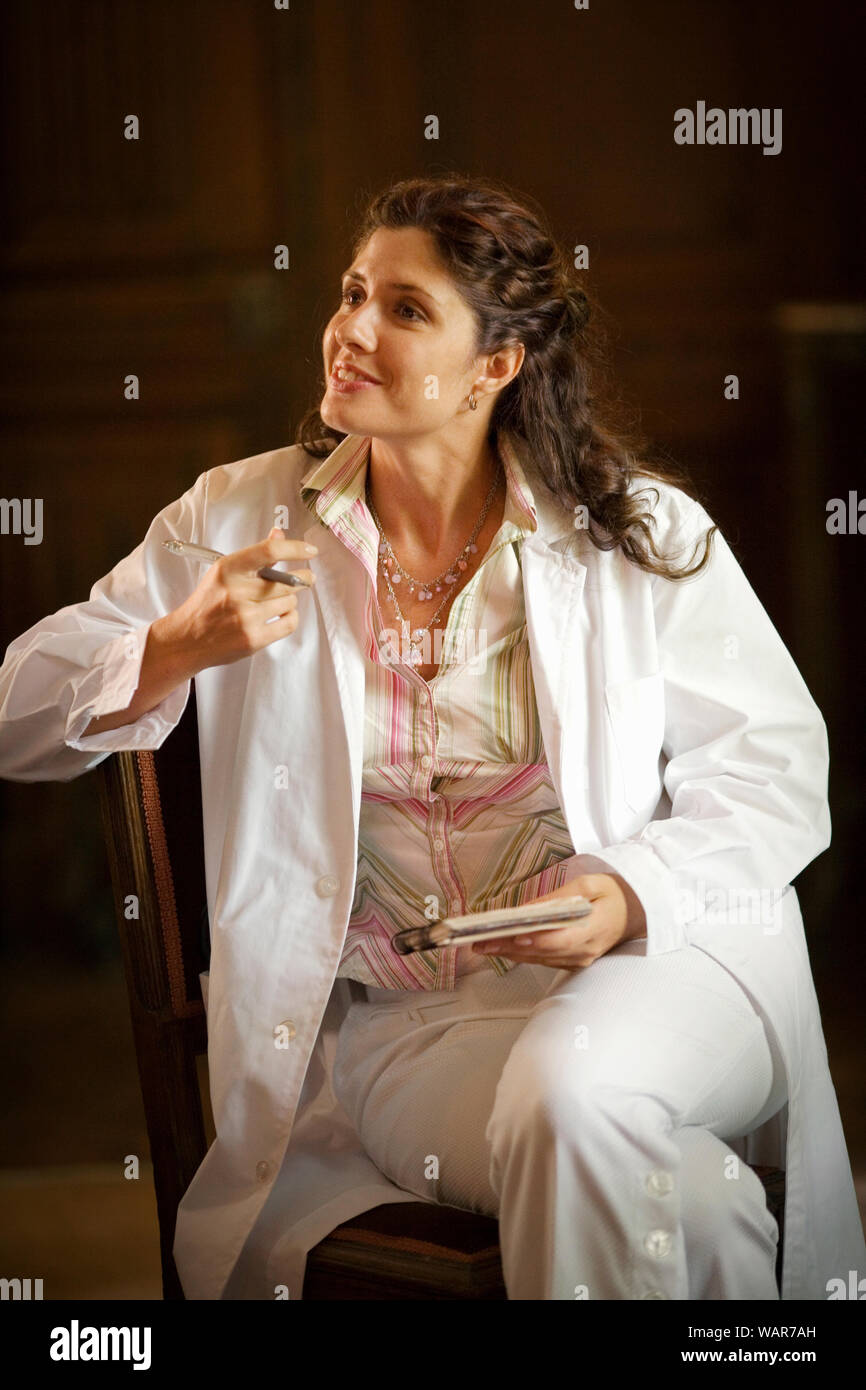 Portrait of a doctor sitting on a chair Stock Photo - Alamy