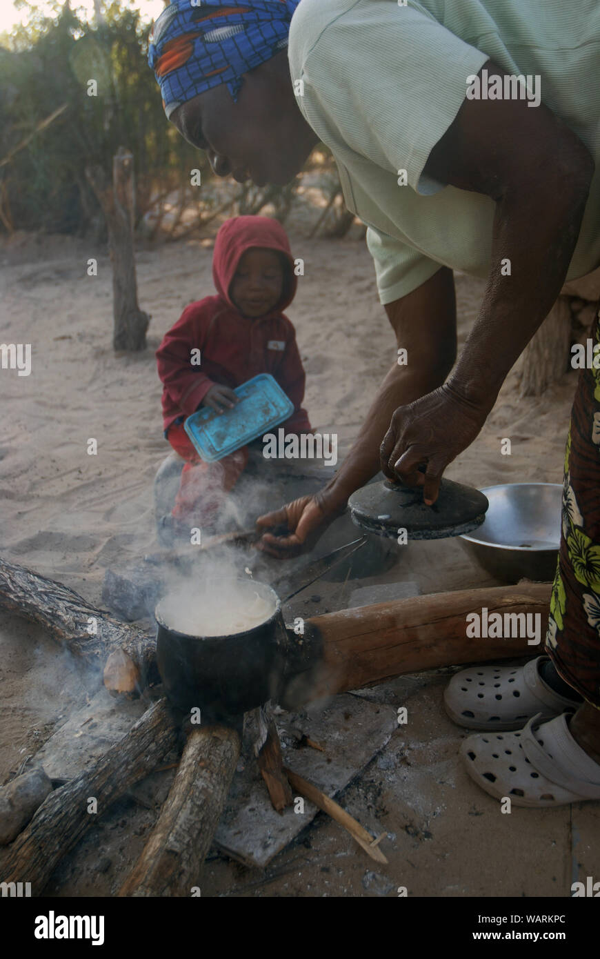 Old lady cooking a pot of Nshima, a thick porridge made from finely ...