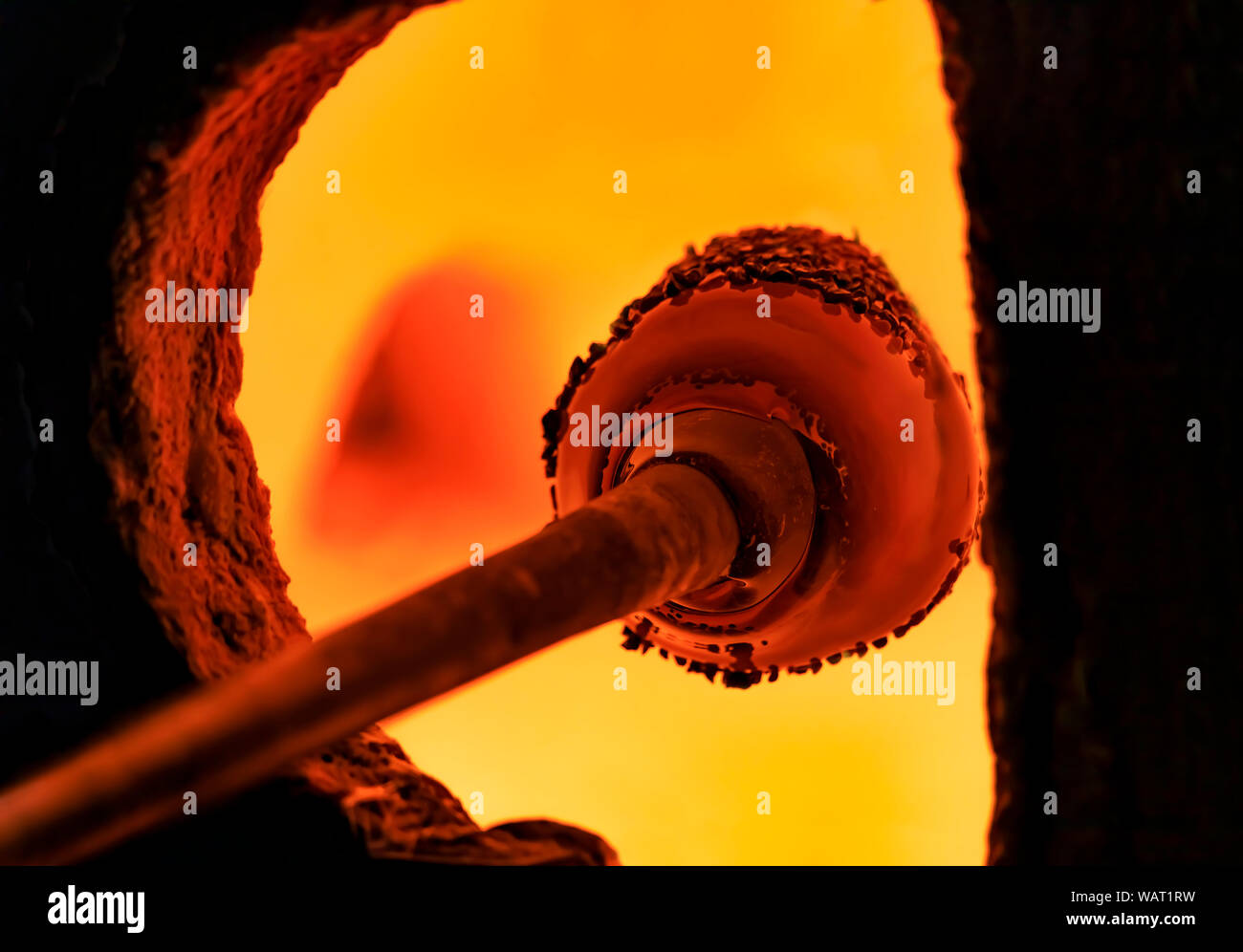 Glass blower manufacturing process, working on a bubble of melted glass ...