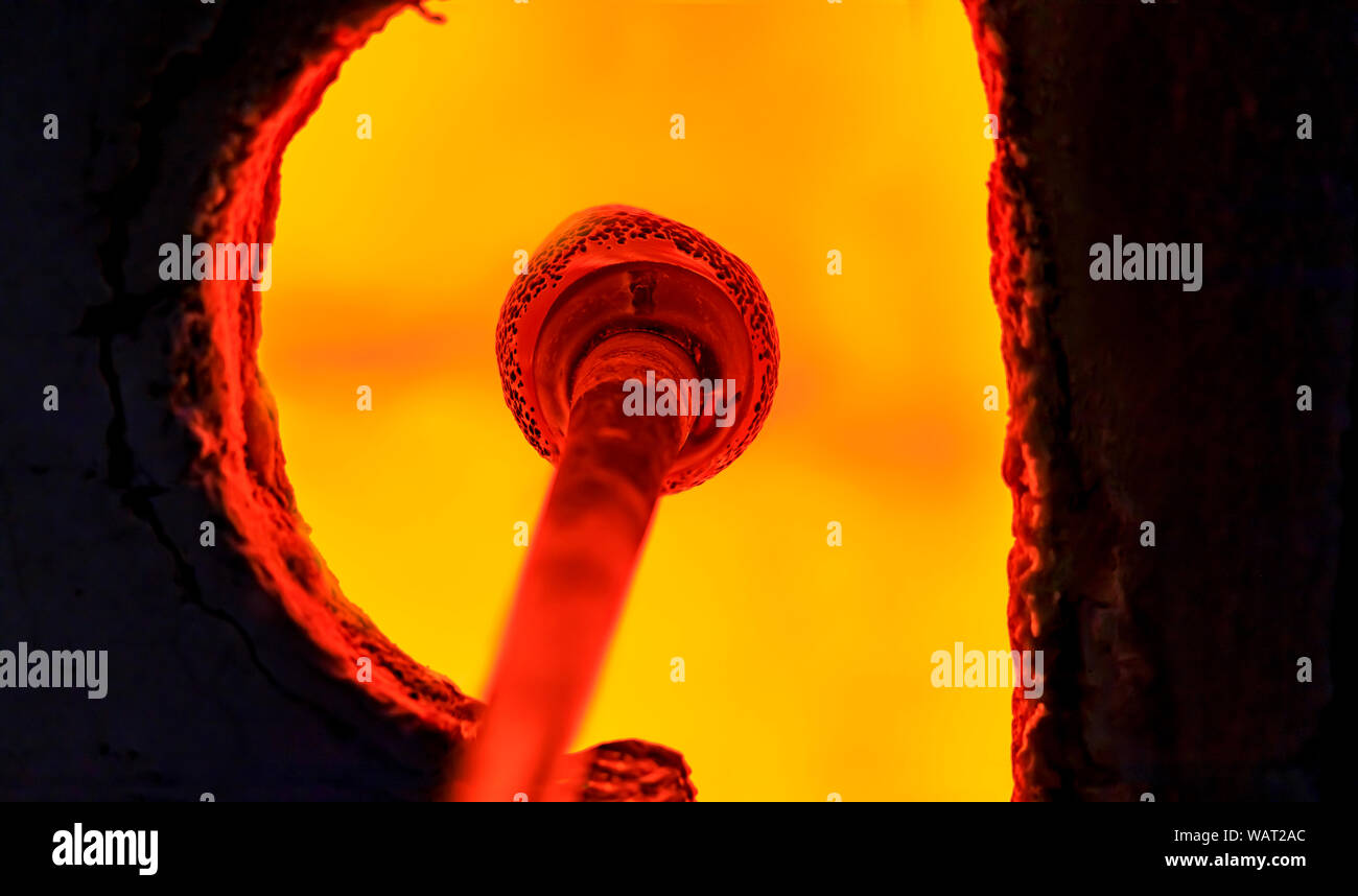 Glass blower manufacturing process, working on a bubble of melted glass ...