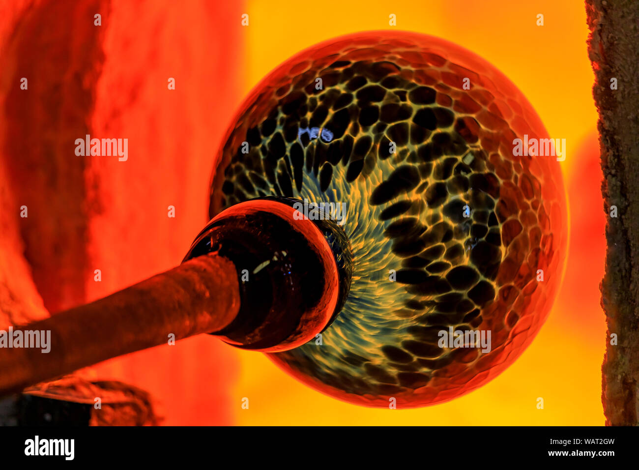 Glass blower manufacturing process, working on a bubble of melted glass ...