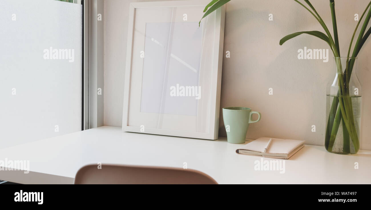 Minimal workplace with mock up frame and copy space with white table ...