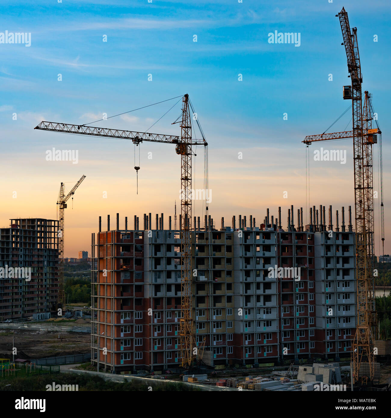 Under construction high-rise building with yellow construction crane in ...