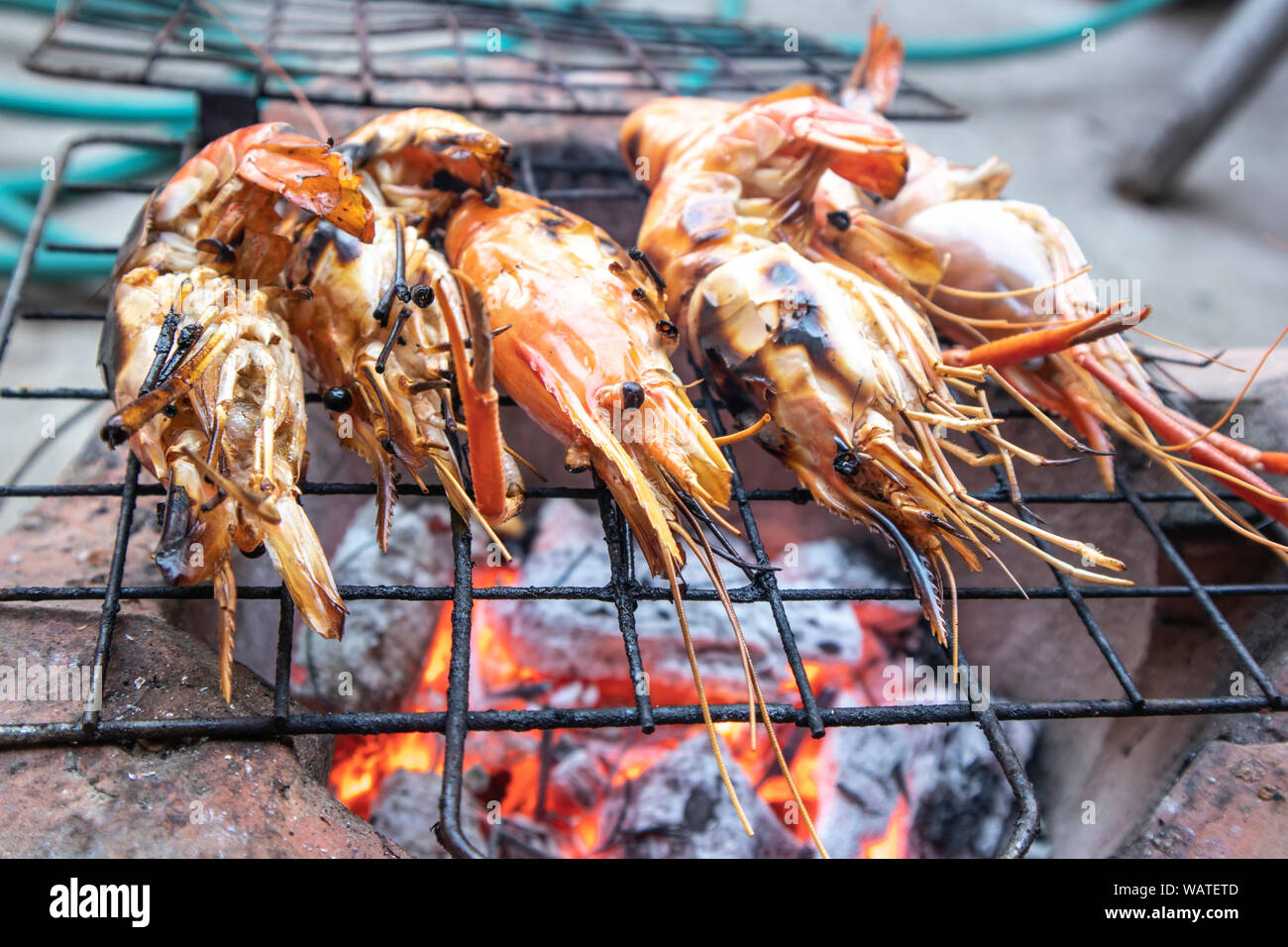 Delicious grilled prawns on flaming grill. Burnt shrimp cooking seafood ...