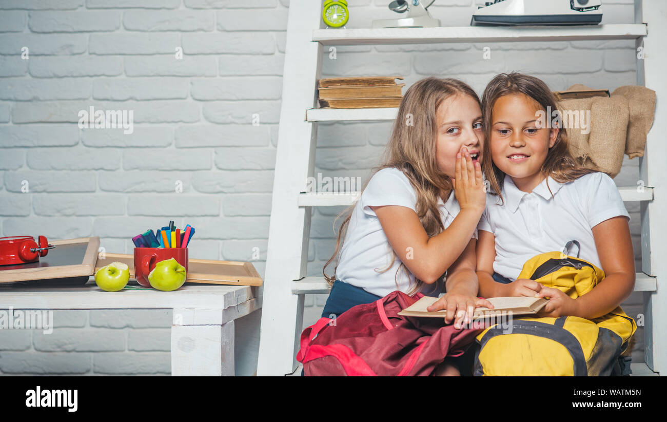 Happy school girls reading a book in library at school Stock Photo - Alamy