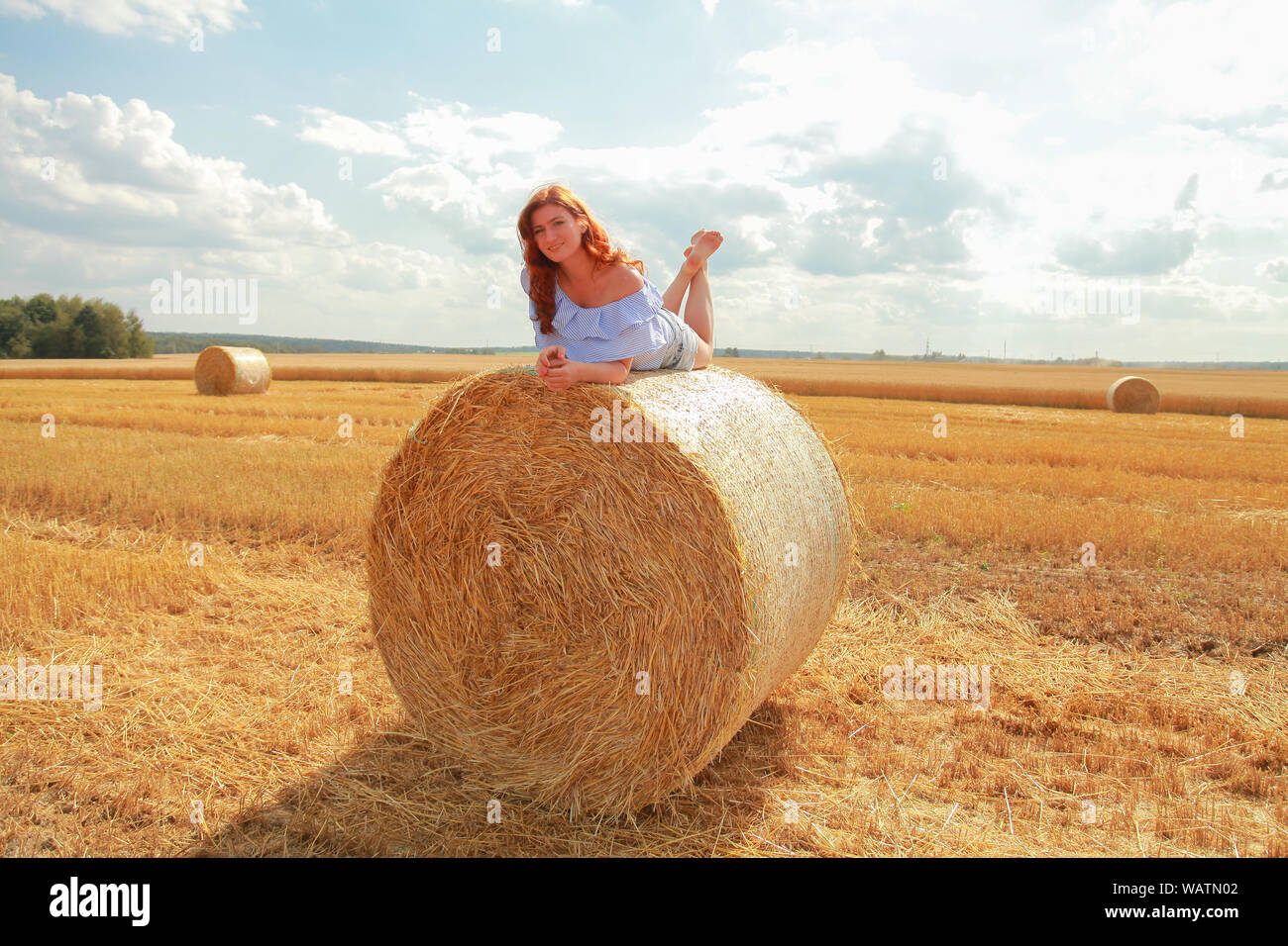 pretty redheaded woman walking in the field mneadow with wheat and ...