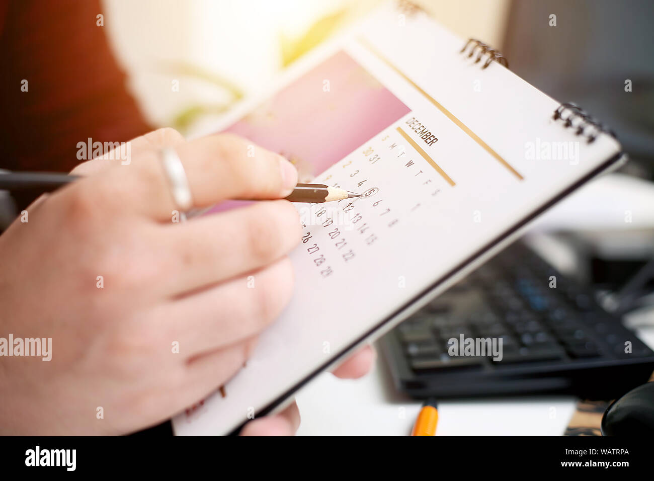 Picture of Man writing on a notebook with a pen and holding mobile in ...