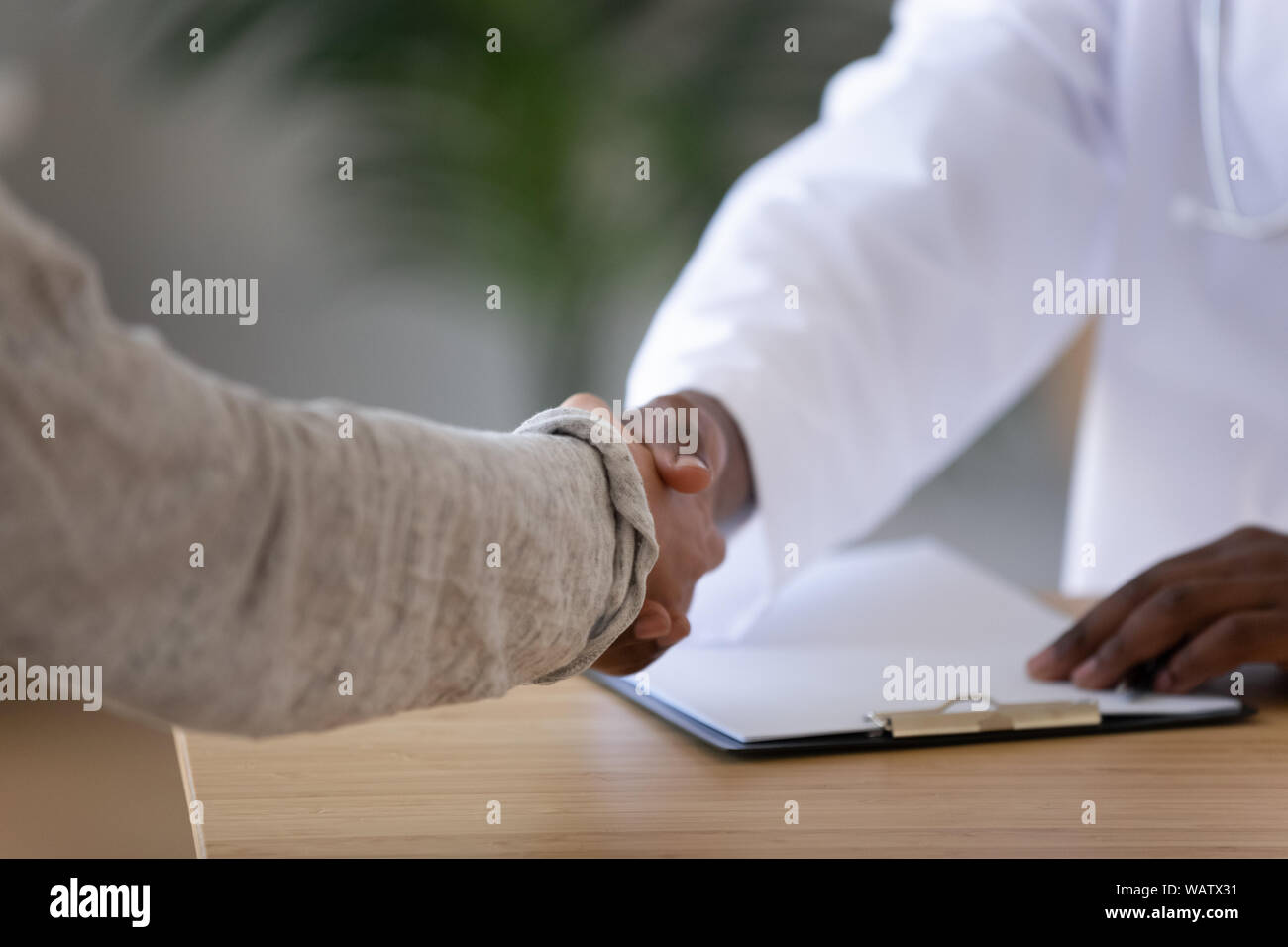 Male black doctor handshake female white patient, close up view Stock ...