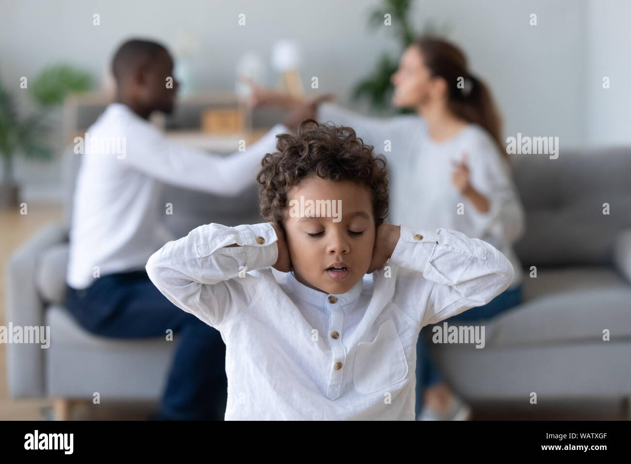 Upset african kid son closing ears not listening parents fighting Stock ...