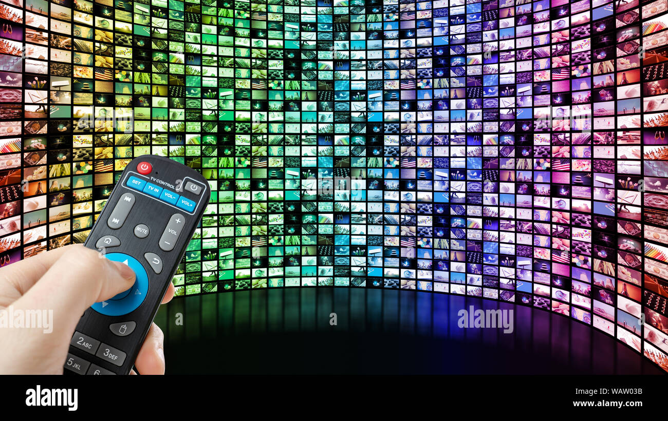 Image of large screen with many multi-colored channels, hands of man ...