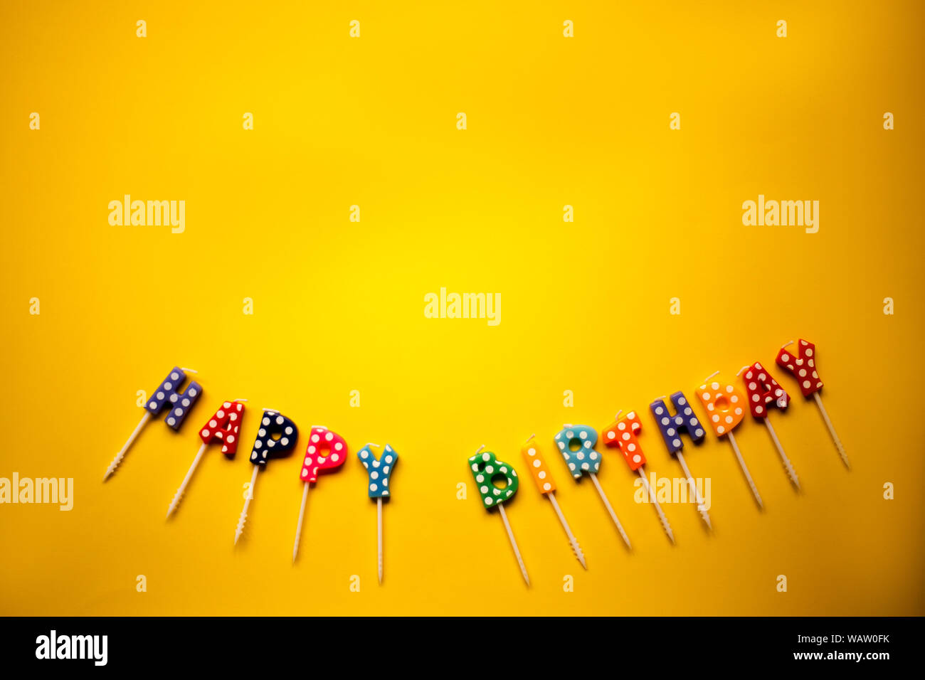 Happy birthday letters in rainbow colors on bright yellow background ...