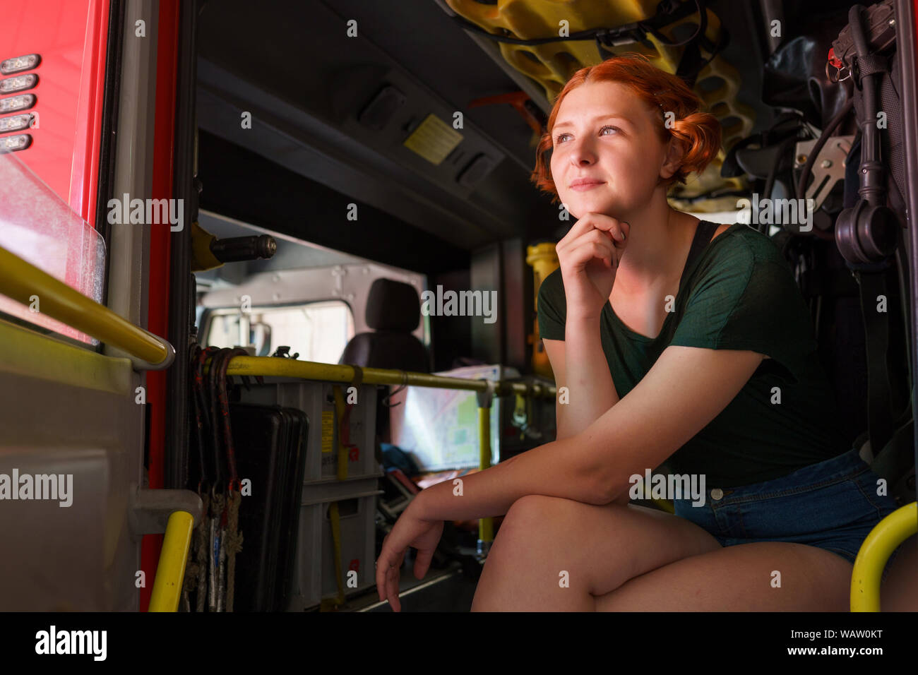 Photo of ginger girl looking to side sitting in cab of fire engine at ...
