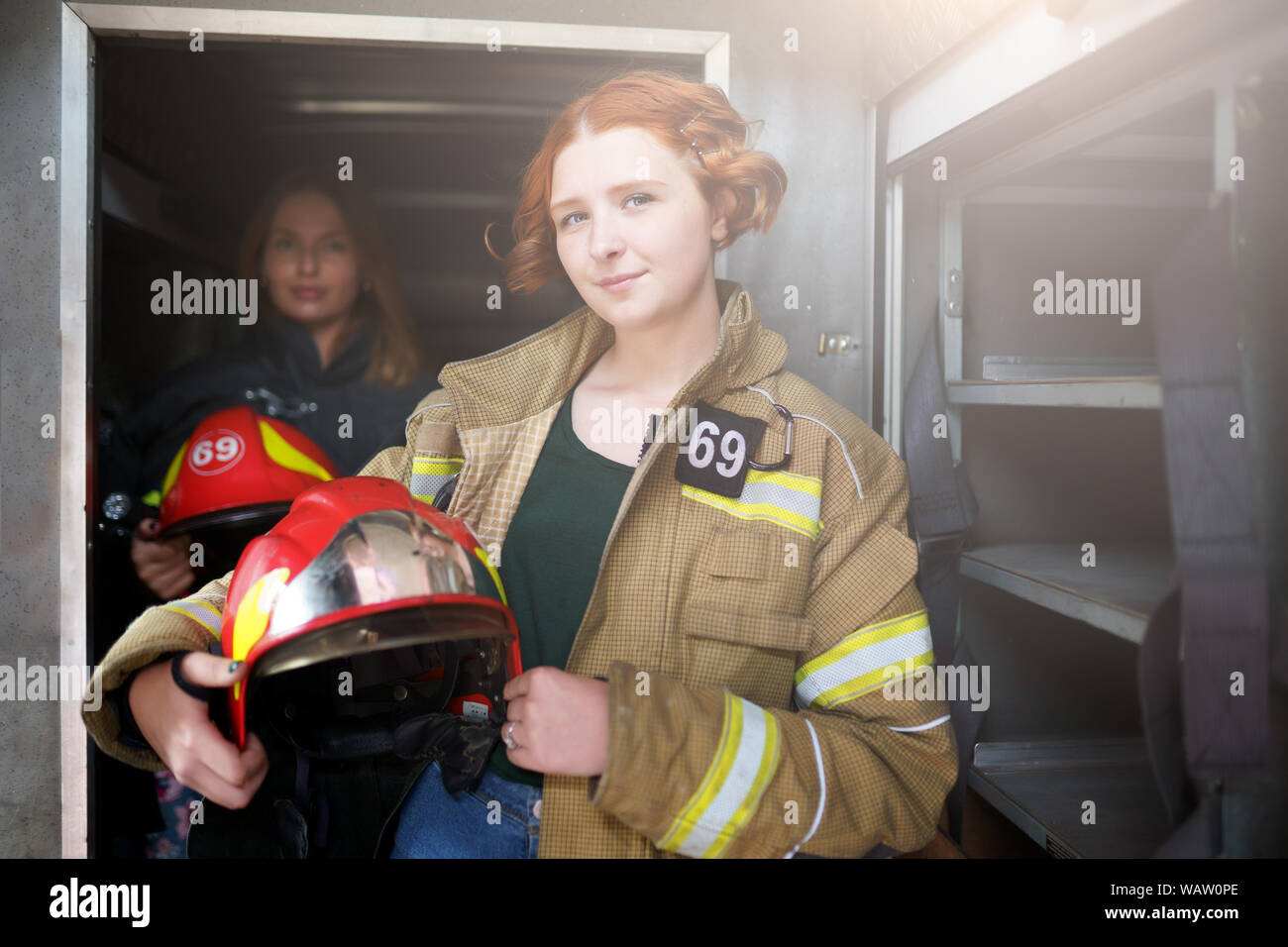 Image of two female firefighters in fire truck at station Stock Photo ...