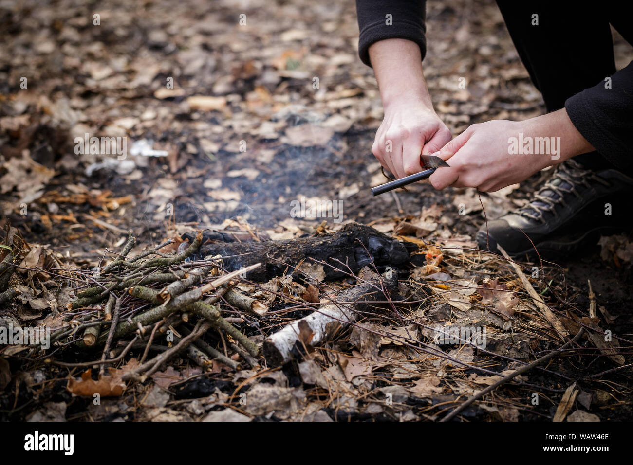 A man makes a fire with a flint Stock Photo - Alamy