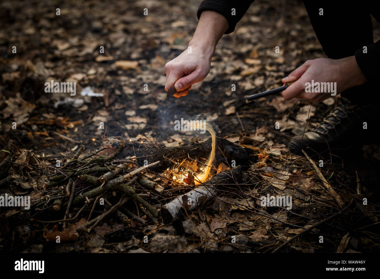 A man makes a fire with a flint Stock Photo - Alamy