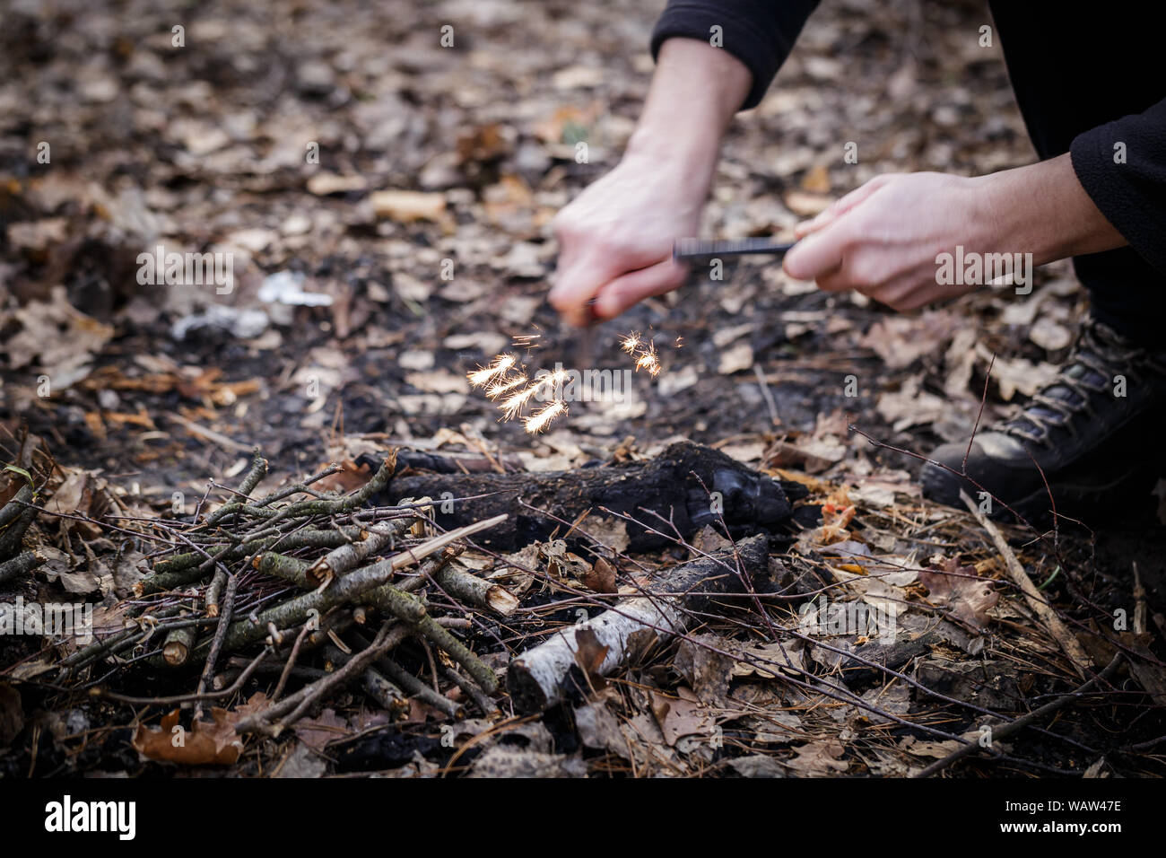A man makes a fire with a flint Stock Photo - Alamy