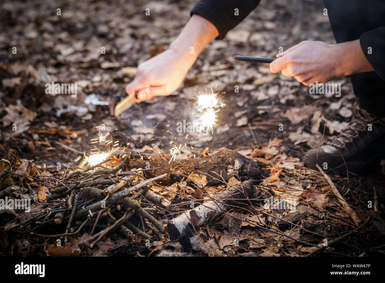 A man makes a fire with a flint Stock Photo - Alamy