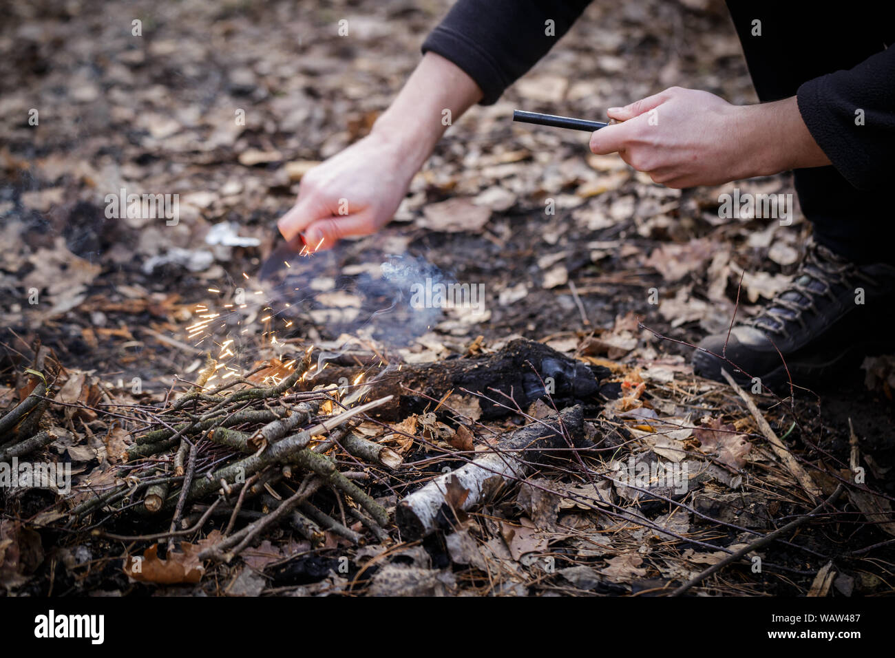 A man makes a fire with a flint Stock Photo - Alamy