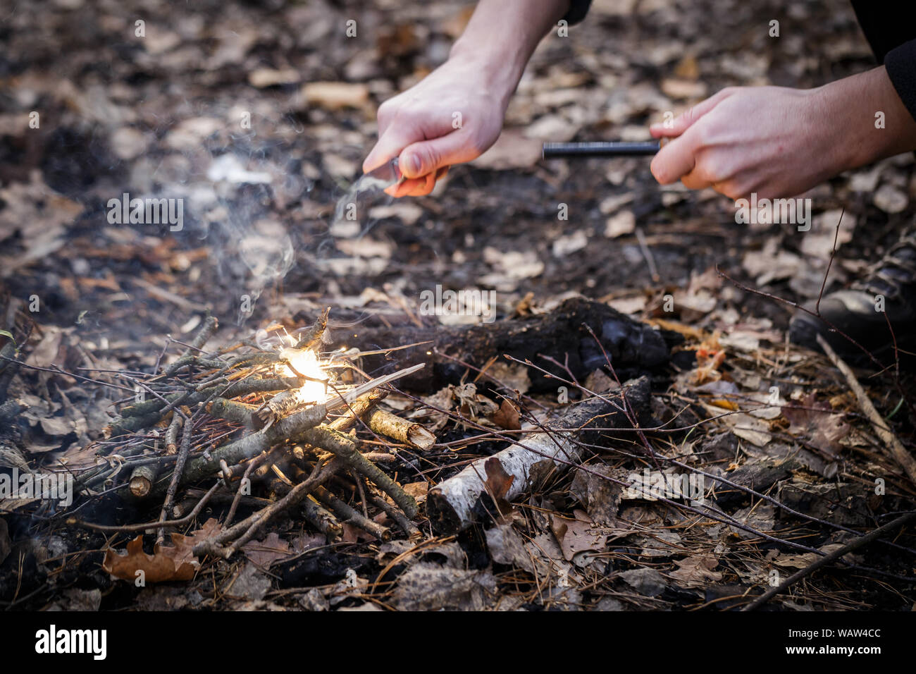 A man makes a fire with a flint Stock Photo - Alamy