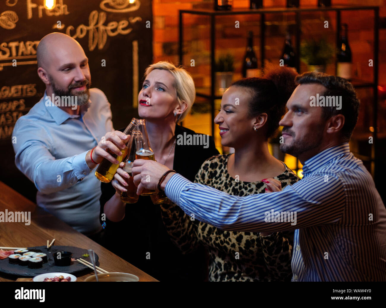Group of friends watching tv in a cafe behind bar counter Stock Photo ...