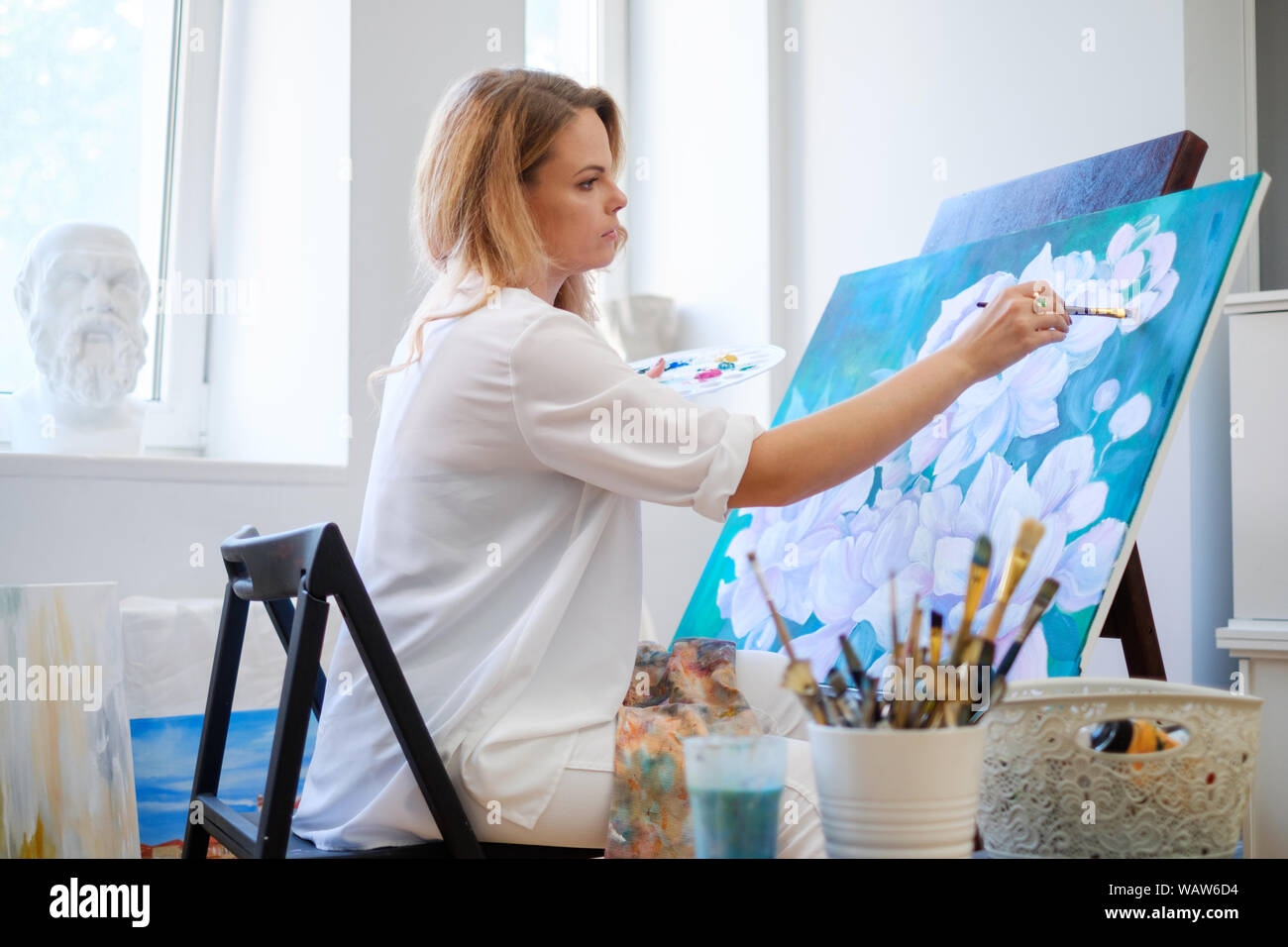 Creative painter paints a colorful picture in her studio Stock Photo ...