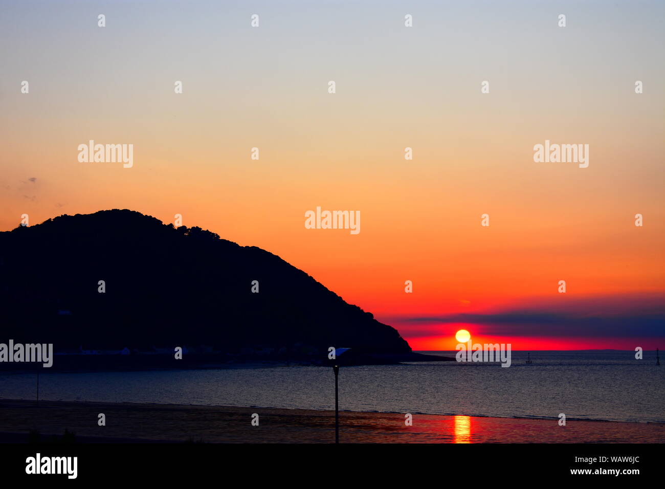 Sunset over beach Stock Photo - Alamy